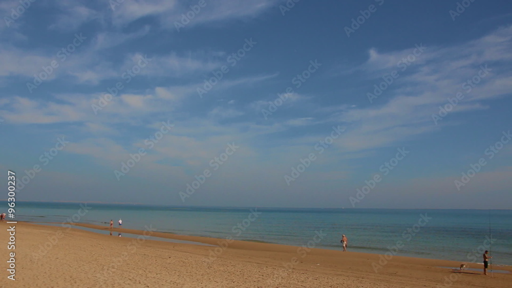 People walking on the beach in the autumn season. Sea, sky and sand ...