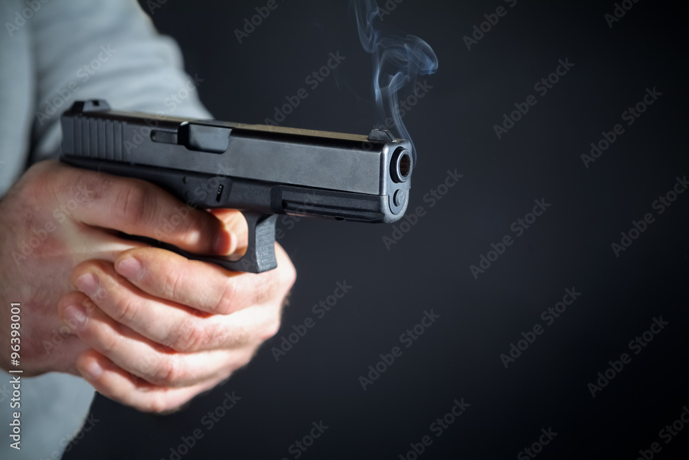 Foto de Male hand with a gun do Stock | Adobe Stock