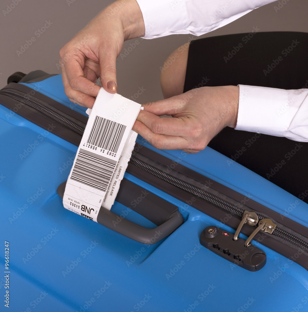 Airline check in luggage tag being attached to a suitcase Stock Photo ...