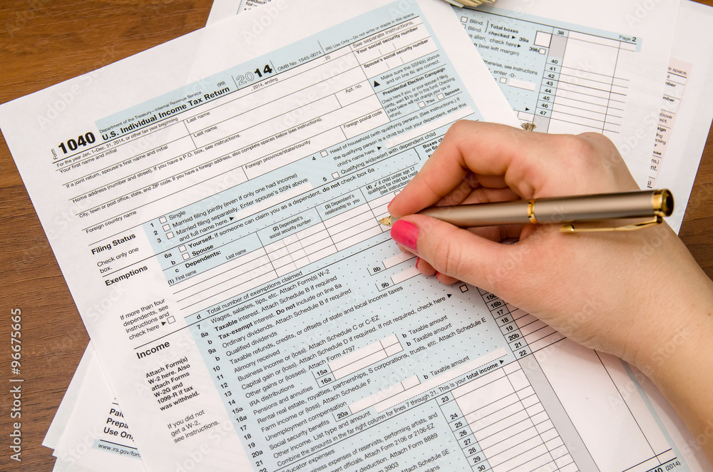 Woman hand filling income tax forms 1040 Stock Photo | Adobe Stock