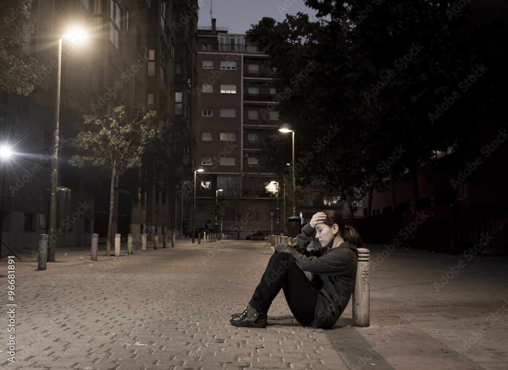 young sad woman sitting on street ground at night alone desperate Stock ...