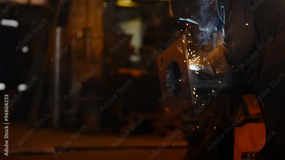 Welding Engineer weld attaching the base of pipes.a lot of sparks ...