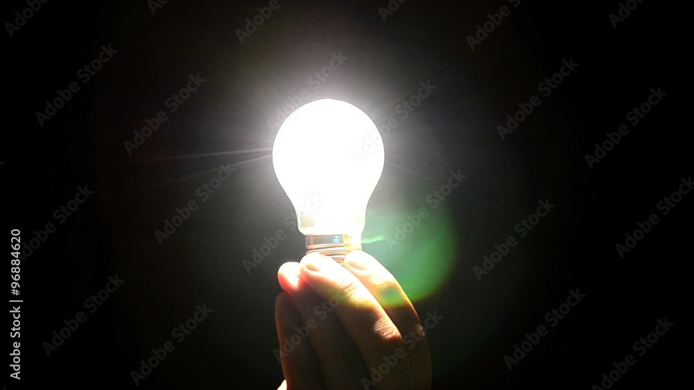 hand holding a light bulb in the dark, the lamp lights up Stock Video ...