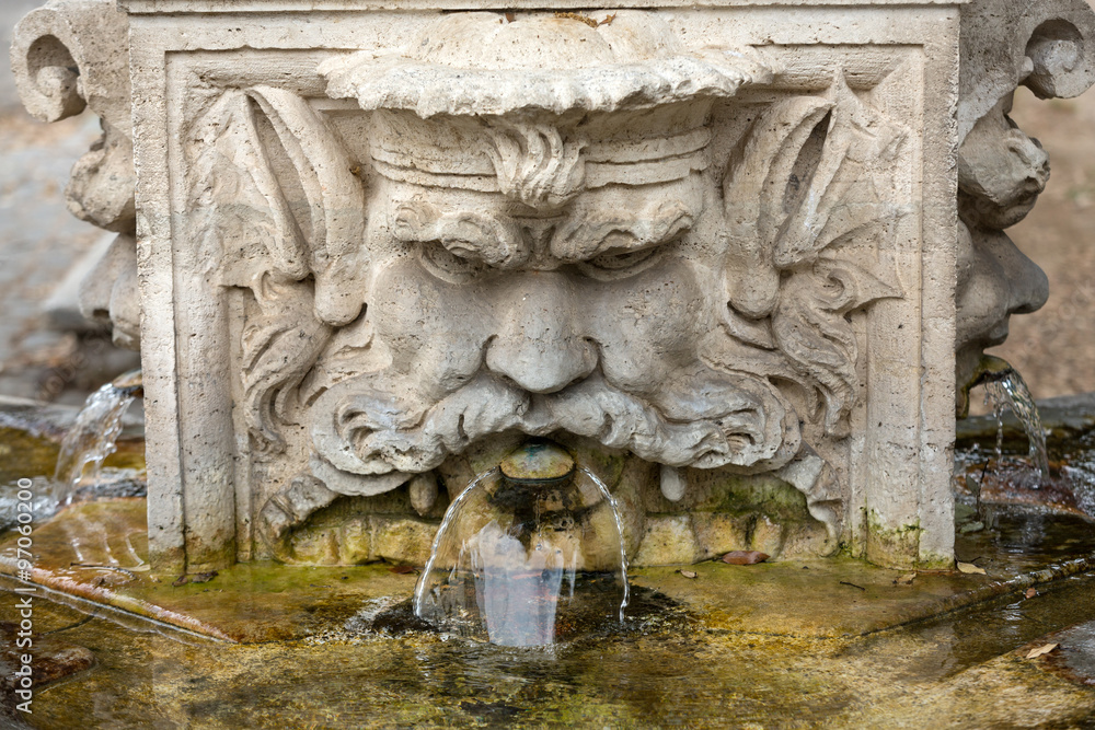Marble fountain in the shape of the head of a man in the gardens of ...