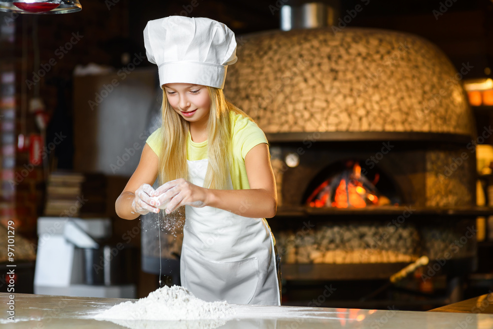 Funny happy chef girl cooking at restaurant kitchen and knead the dough ...