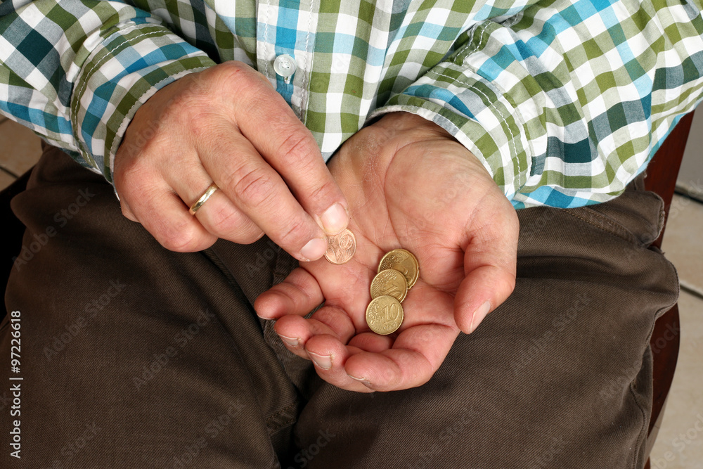 Mann zählt Kleingeld in geöffneter Hand Stock-Foto | Adobe Stock