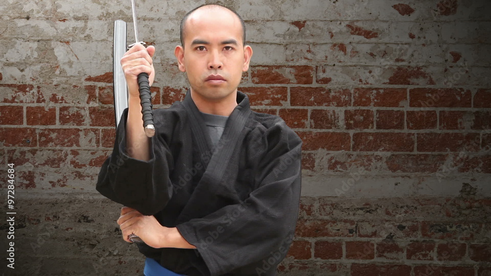 Asian man in a Japanese Gi draws a Samurai Sword, and slashes through ...