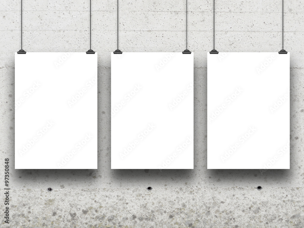 Three hanged paper sheet frames with clips on grey concrete wall ...
