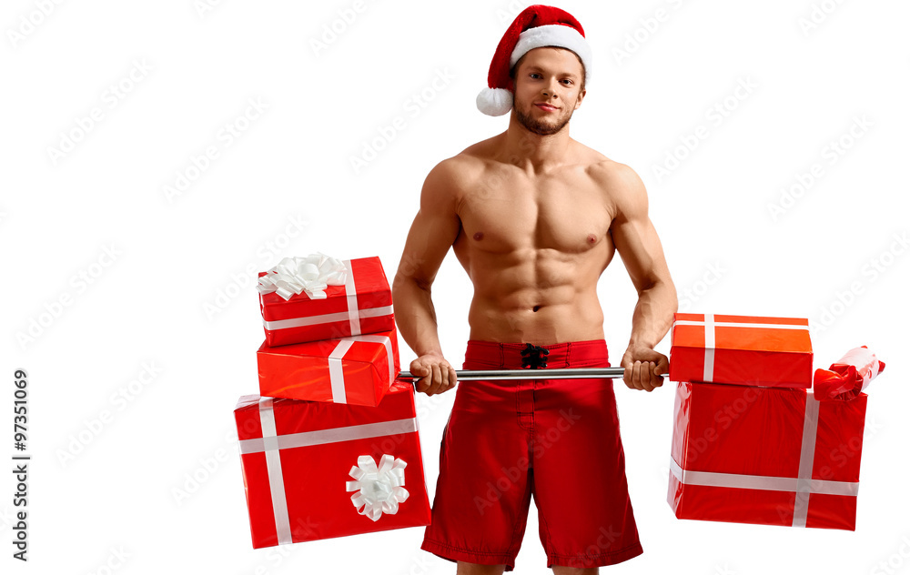 Hard work pays off. Toned Santa Claus holding a barbell with presents ...