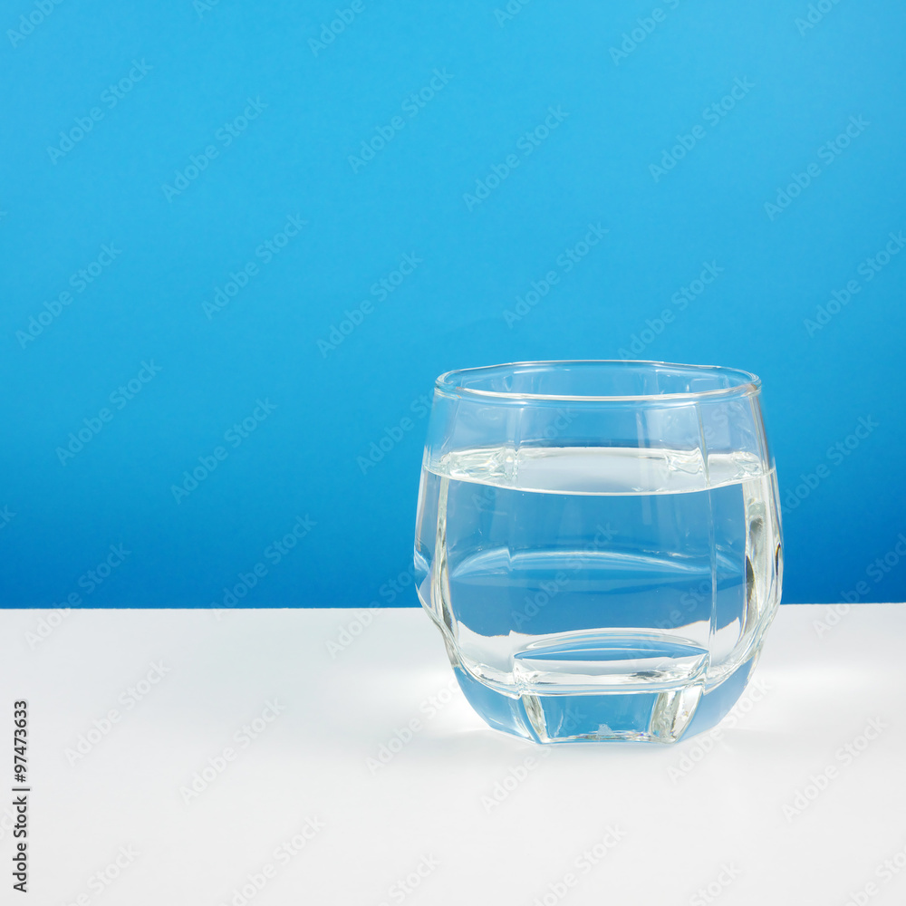 The medium glass of pure water on a white table. Stock Photo | Adobe Stock