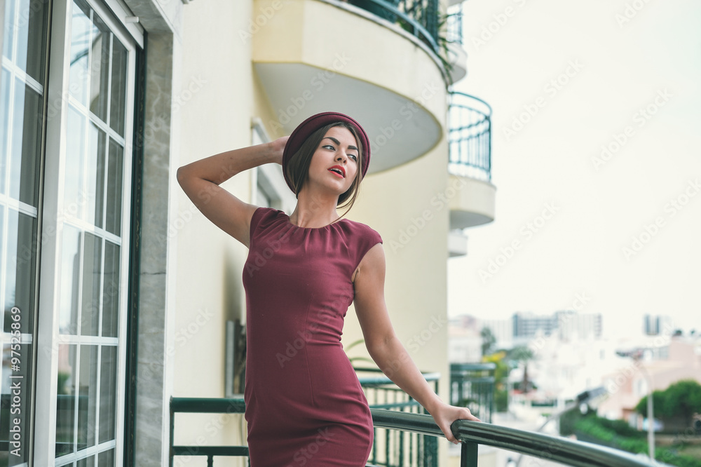 Stunning lady in dark red dress posing standing on balcony Stock Photo ...