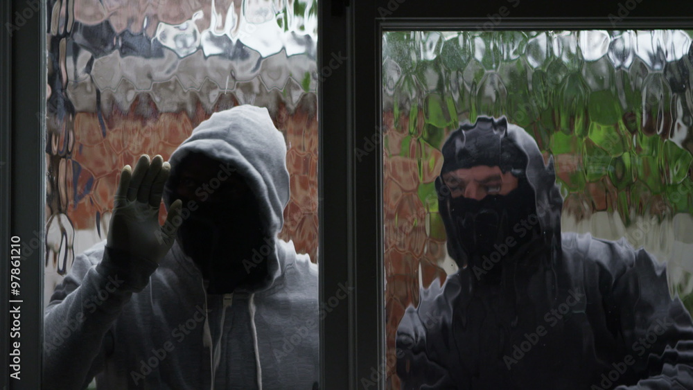2 masked burglars breaking and entering into a victim's home Stock ...