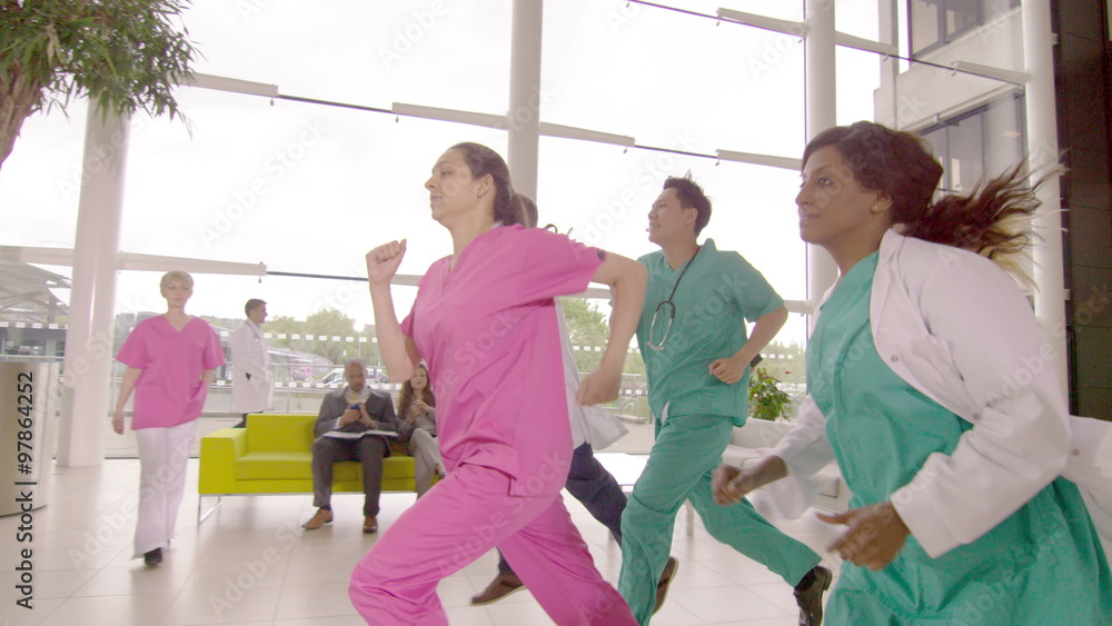 Medical team running through hospital building, responding to an ...
