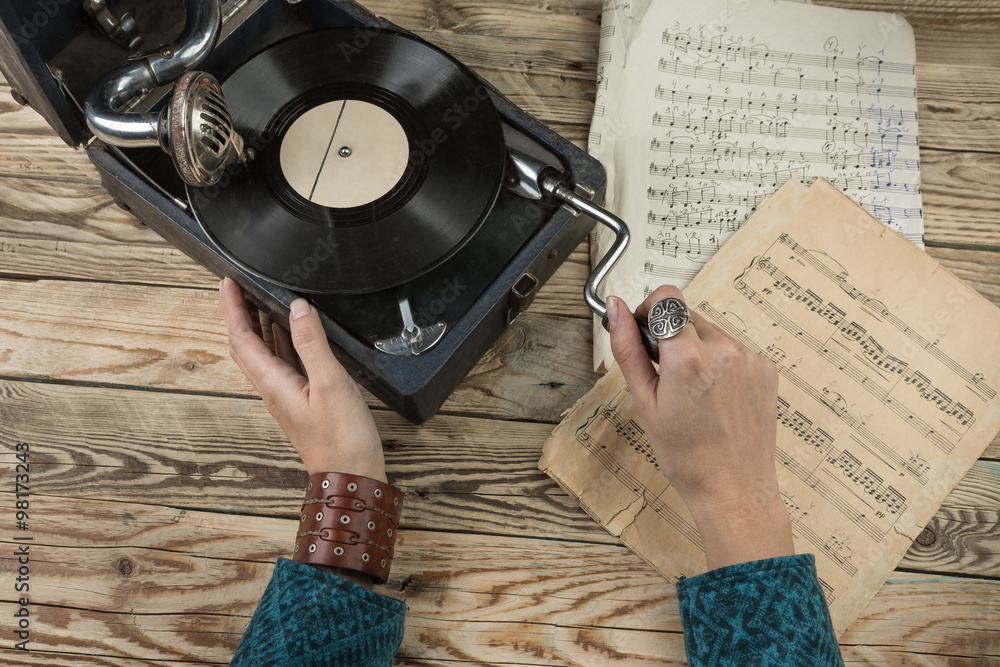 woman using retro old gramophone with black vinil plate for playing ...