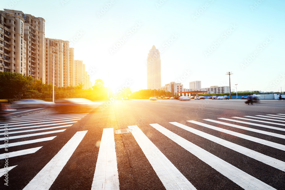 sun skyline and traffic on urban road through city buildings Stock ...