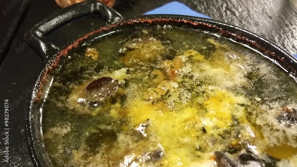 Bubbling, cooked escargot snail pan, at a restaurant kitchen Stock ...
