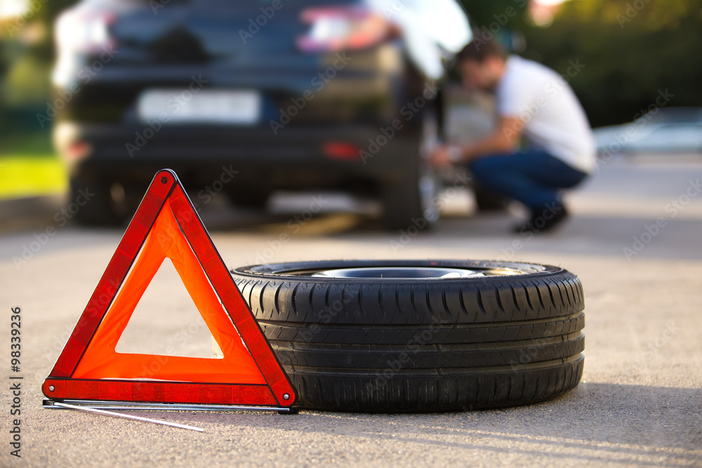 Sad and depressed man sitting near car with punctured tire Stock Photo ...
