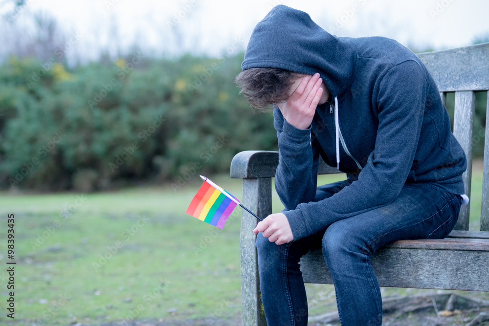 Depressed Teenage Boy Holding A Pride Flag Stock Photo | Adobe Stock