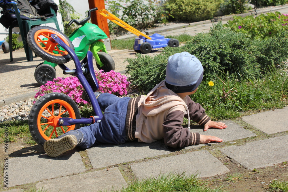 The little boy fell off the bike at first individual driving.The little ...