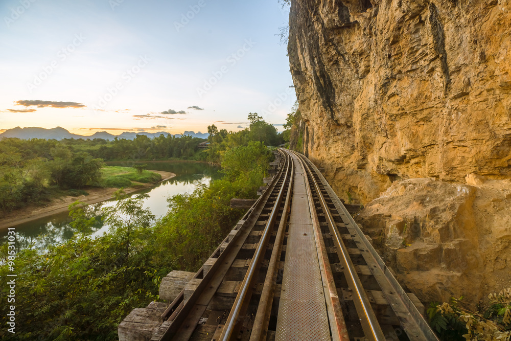 Railroad tracks parallel to the steep cliff. Stock Photo | Adobe Stock