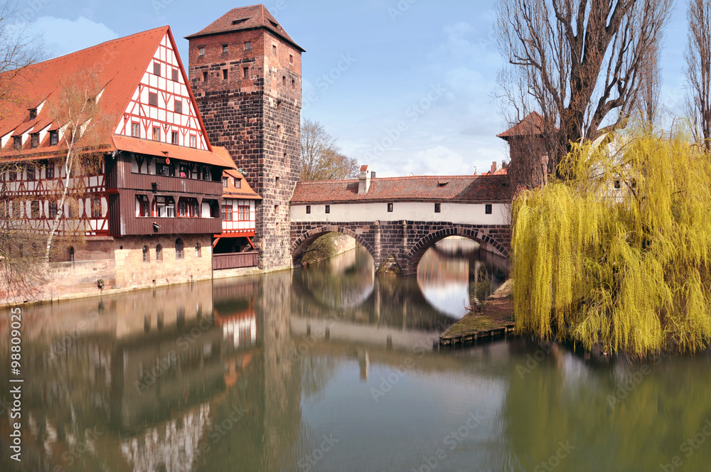 Old buildings, arch bridge and tree reflection in water. Nuremberg ...