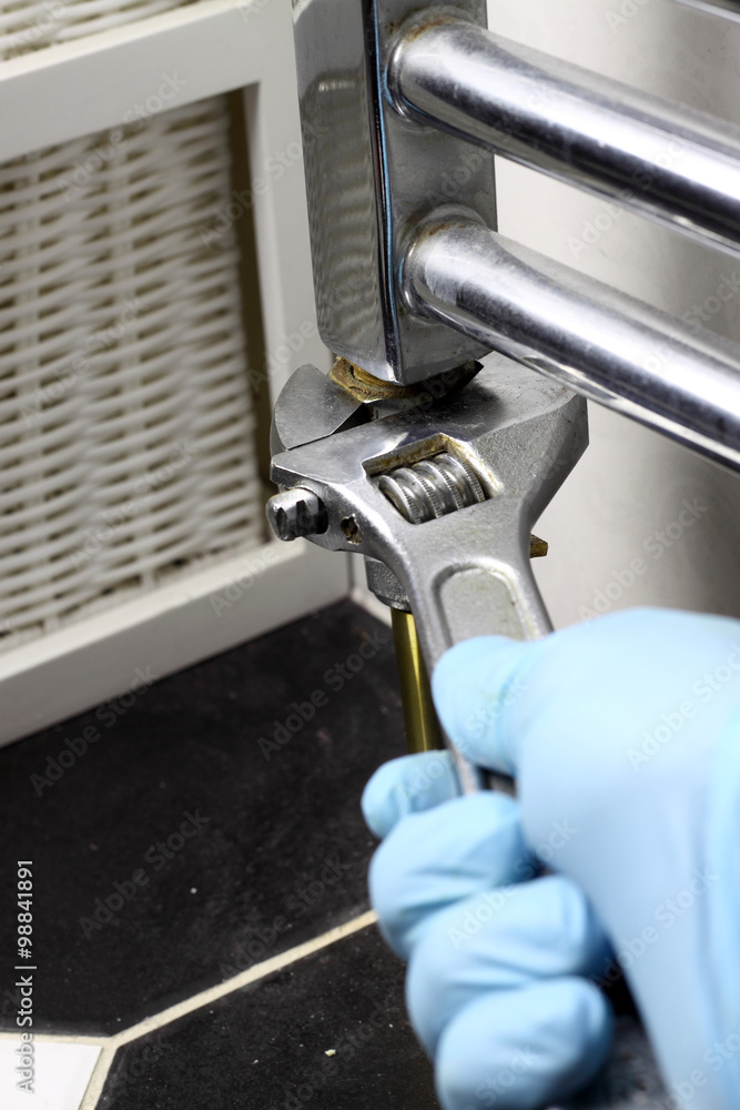 Radiator man tightening spanner / Man connecting modern radiator with a ...