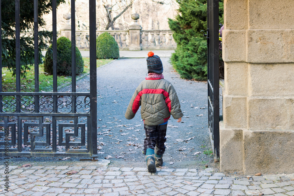Child walking through a gate into a park or garden Stock Photo | Adobe ...