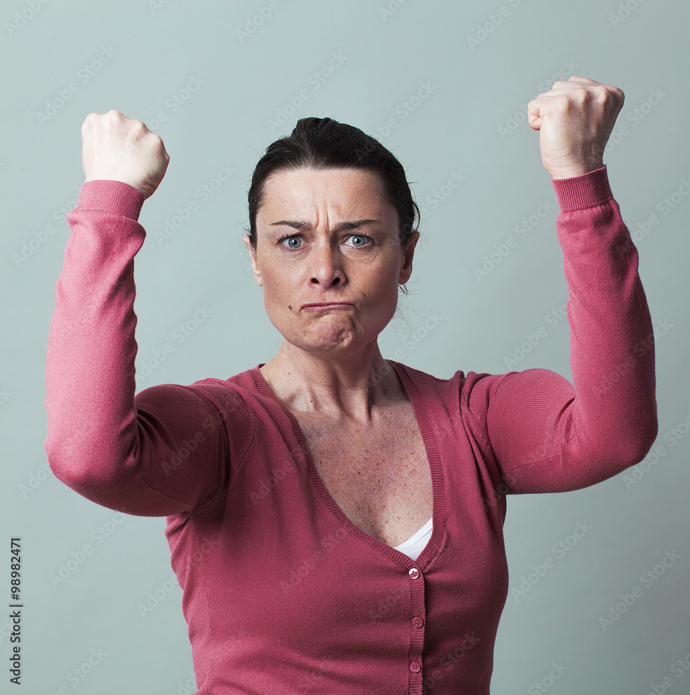 muscle concept - furious 40s woman flexing her muscles up for metaphor ...