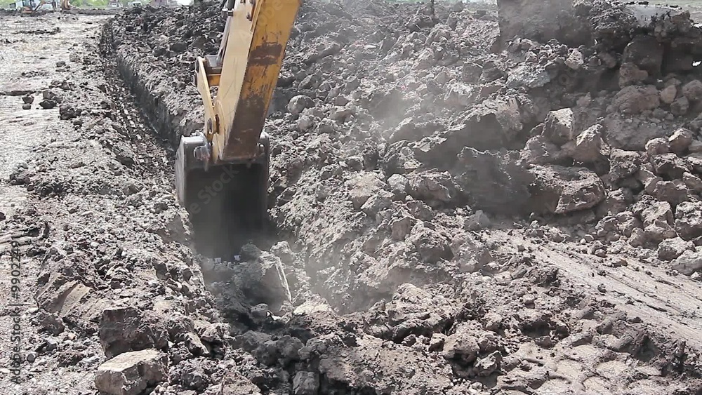 Excavator is excavating a ditch. Backhoe tractor is working on a ...