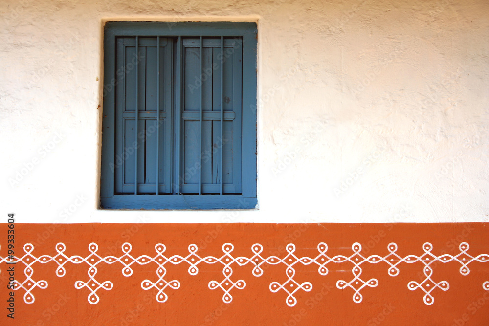 Closeup of a tribal house window with traditional kolam or line drawing ...
