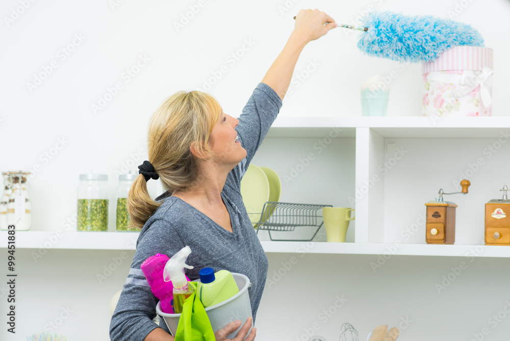frau mit staubwedel beim säubern der wohnung Stock-Foto | Adobe Stock