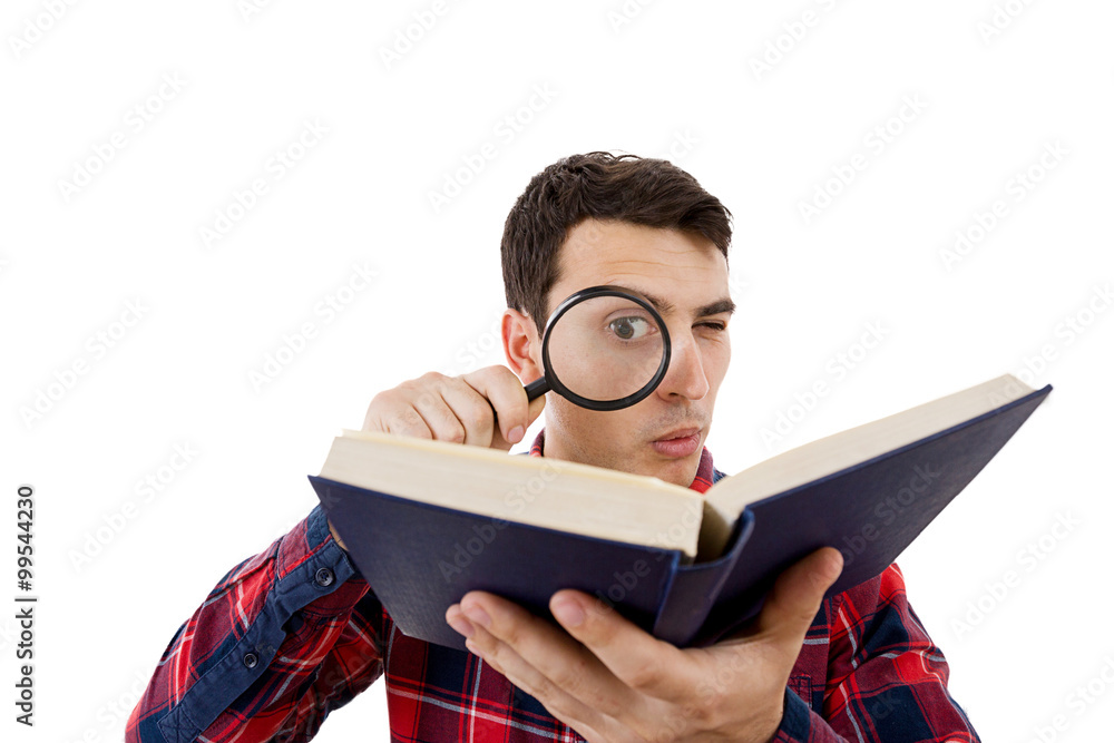 Curious young student man holding book with a magnifying glass ...