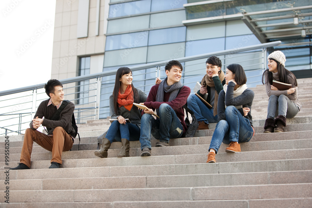 Young college students sitting on steps of university building Stock ...