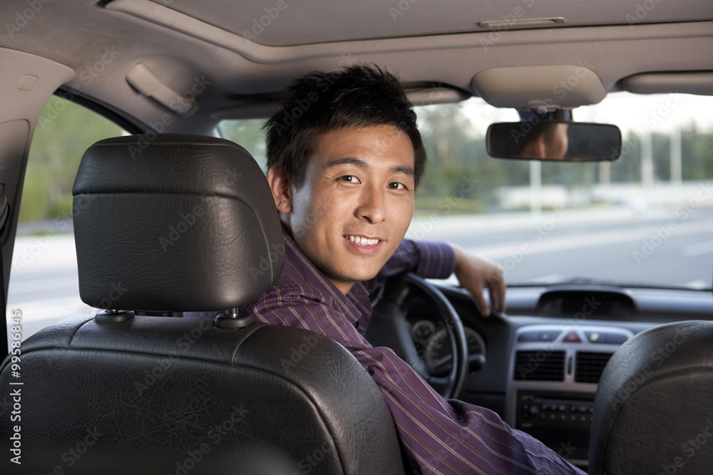 Driver looking back over his shoulder at the camera Stock Photo | Adobe ...