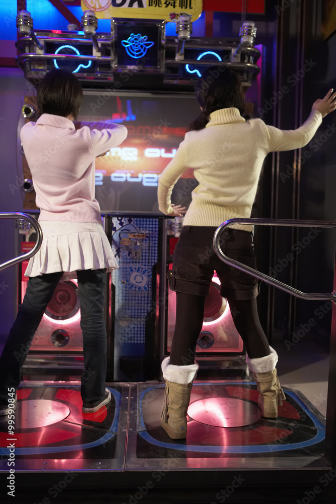 Teenage Girls On Dancing Game At Arcade Stock Photo | Adobe Stock