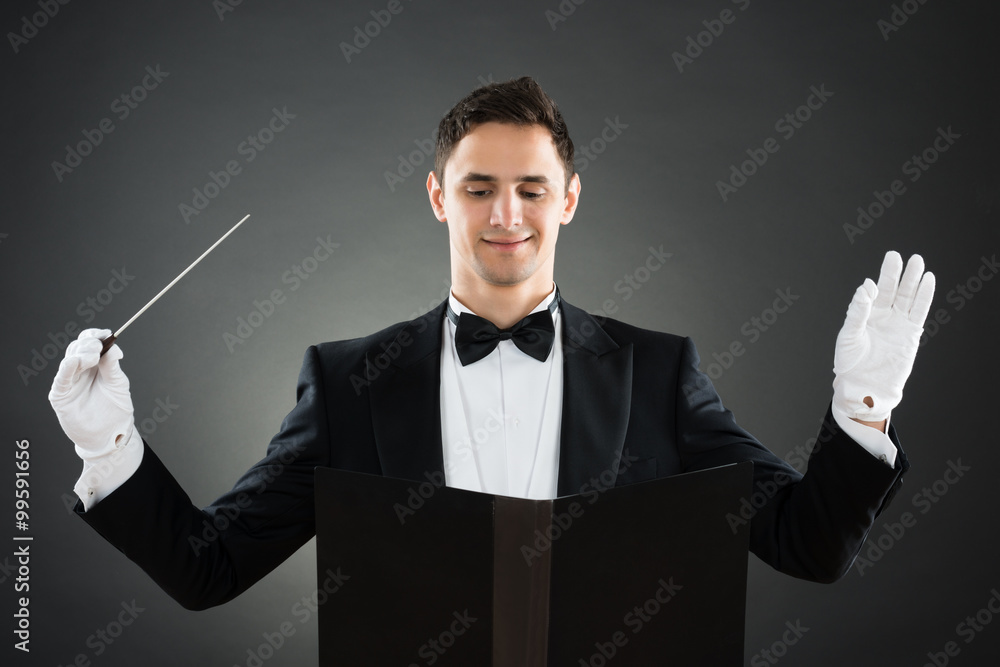 Smiling Music Conductor Holding Baton Stock Photo | Adobe Stock