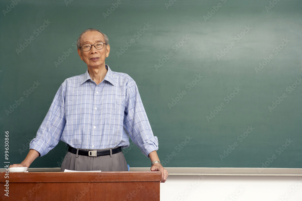Teacher Standing Behind Desk foto de Stock | Adobe Stock Teacher Standing Behind Desk foto de Stock | Adobe Stock