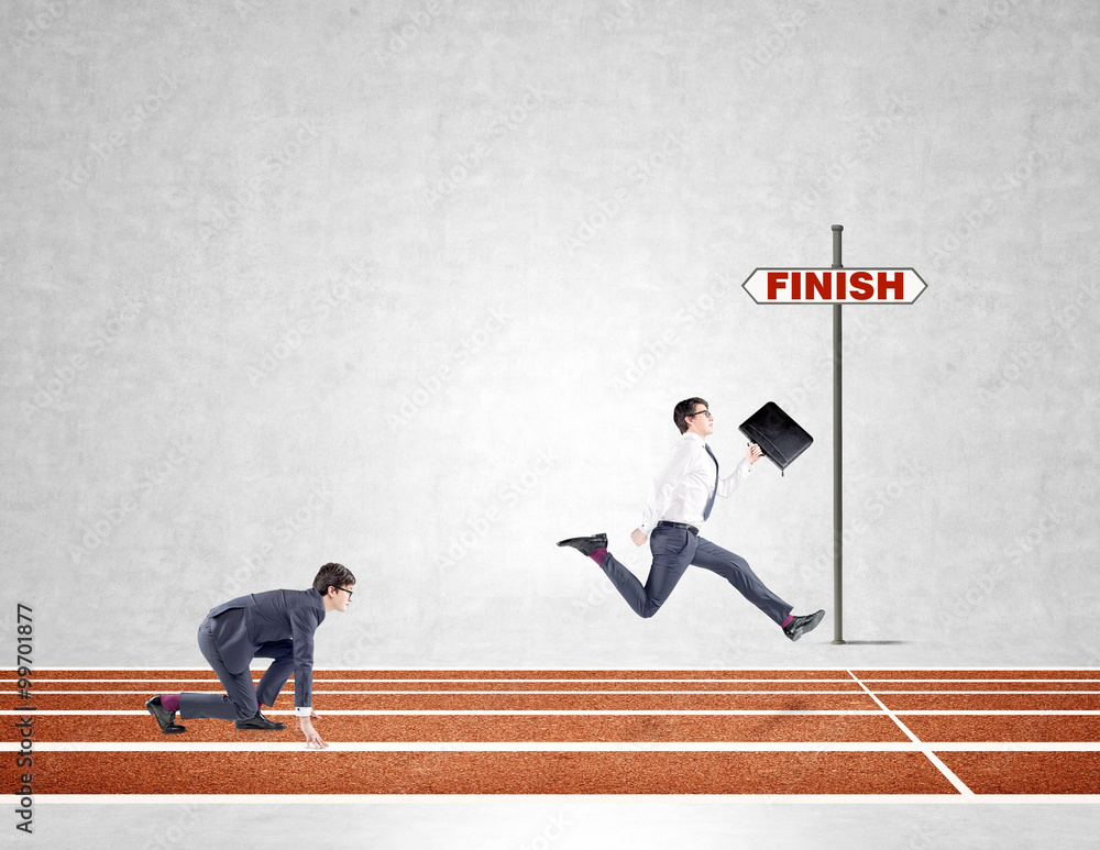 Two young businessmen competing on the track. One in crouch start, the ...