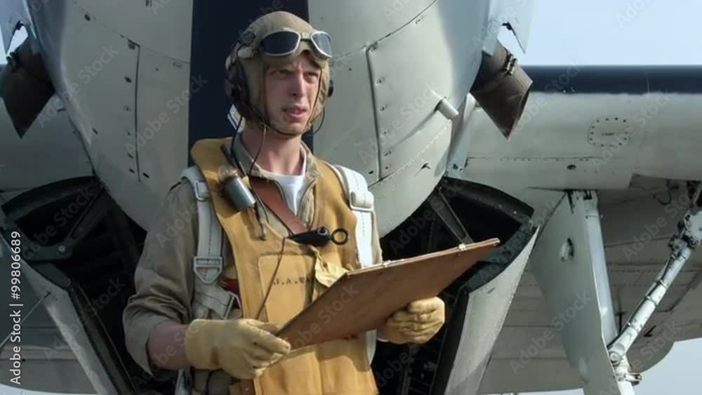 Pilot re-enactor in authentic flight gear checks a flight chart while ...