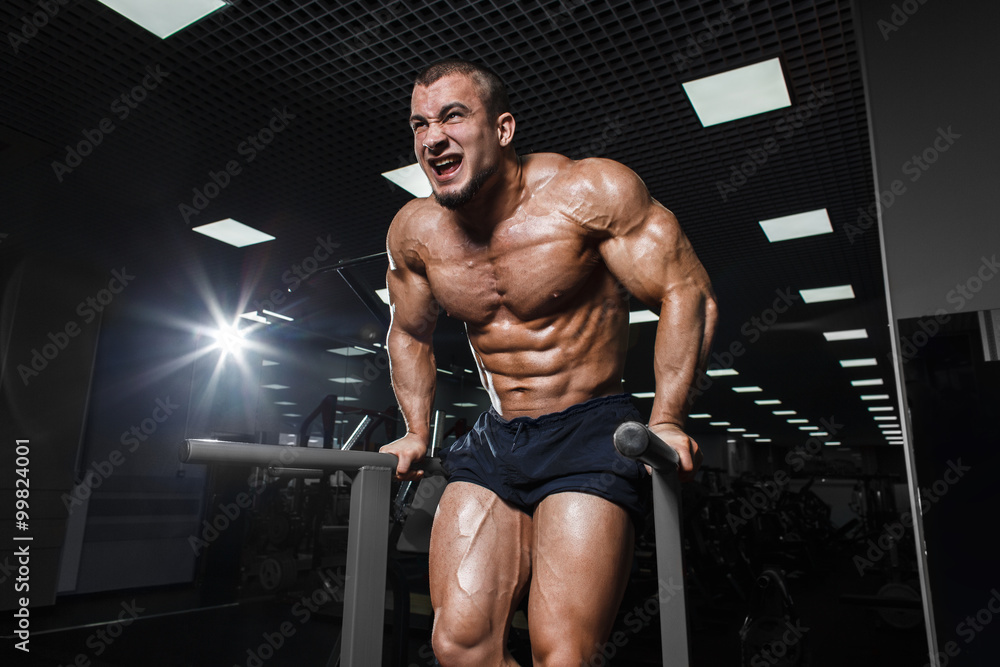 Muscular emotional bodybuilder working out in gym doing exercises on ...