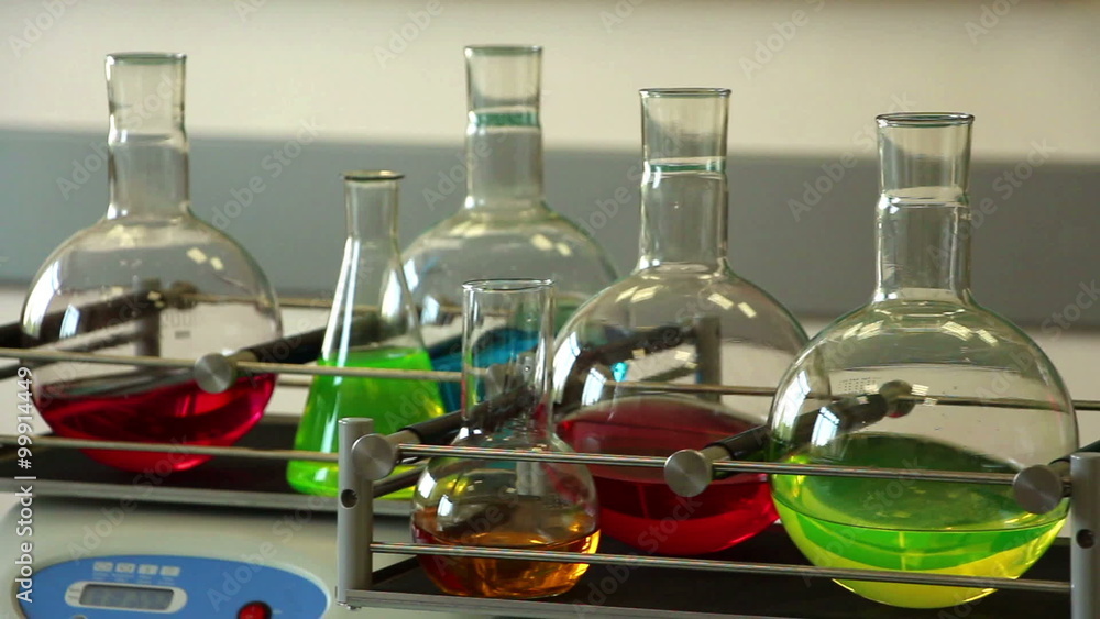 Laboratory shakers synchronously agitate six glass flasks filled with ...