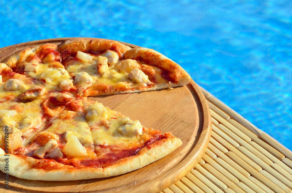 Tasty pizza on the swimming pool background Stock Photo | Adobe Stock