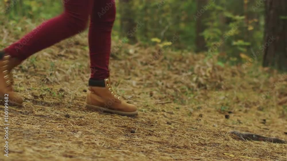 Group of people in close-up leg shot from the side walk down hill in ...