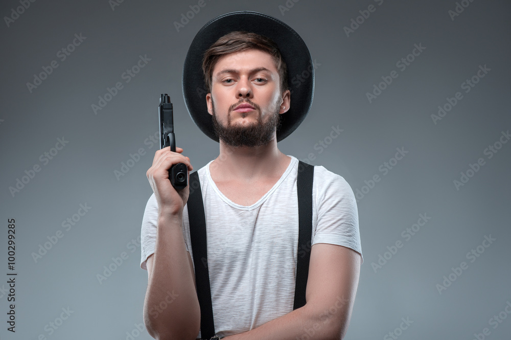 Handsome young guy with gun and hat Stock-Foto | Adobe Stock
