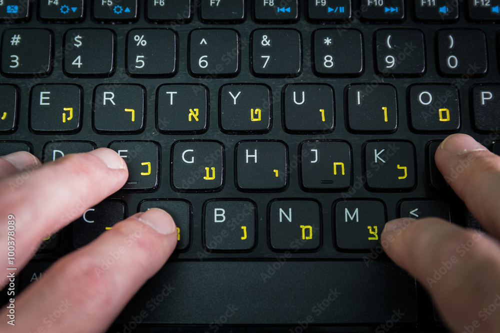 Man typing on a keyboard with letters in Hebrew and English - Laptop ...