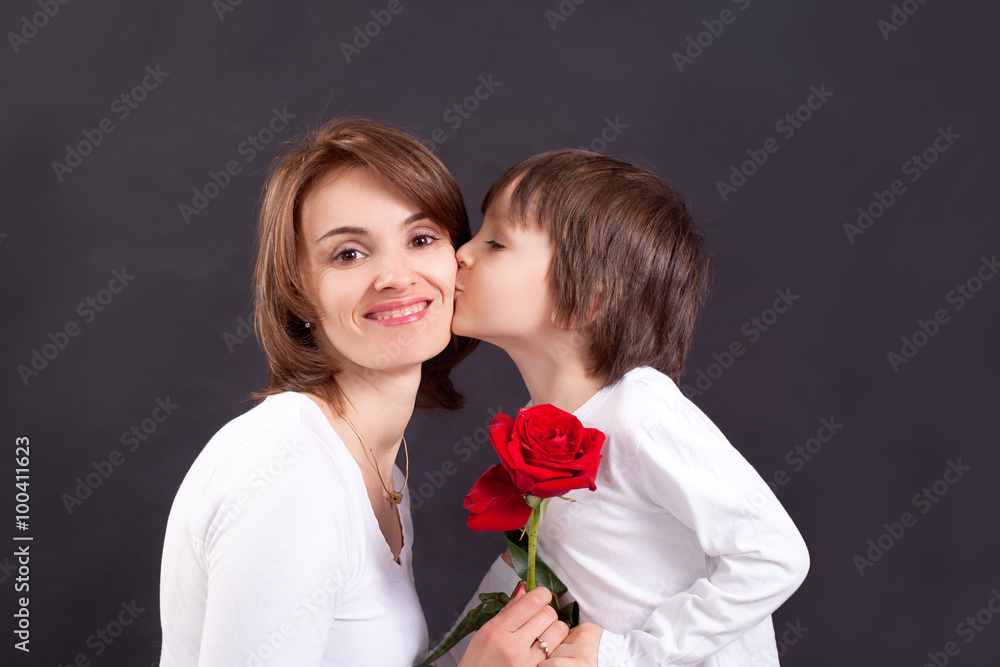 Young kid giving gorgeous red rose to his mom Stock-Foto | Adobe Stock