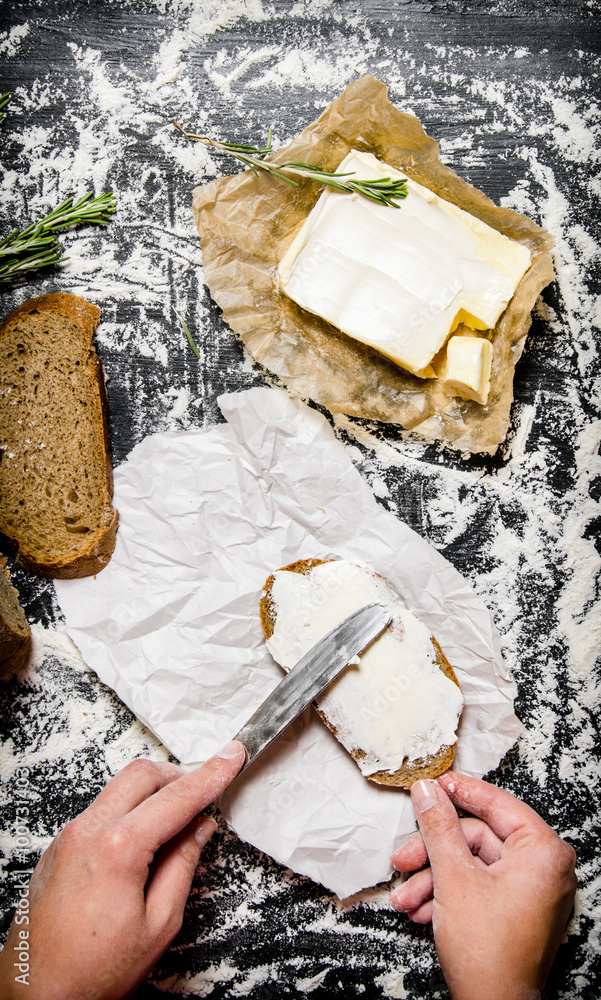 The buttering of bread with butter on Board with flour. Stock Photo ...