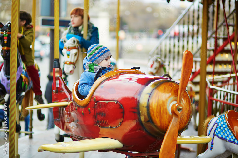 Boy taking a ride in plane on merry-go-round Stock Photo | Adobe Stock
