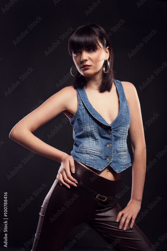 Woman model posing in leather pants and jeans jacket in studio Stock ...
