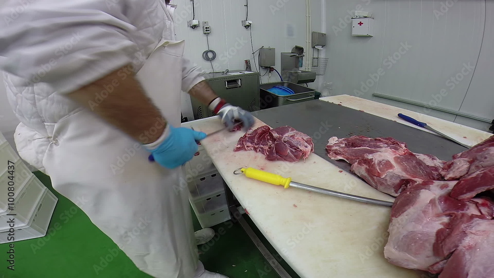 Skilled Butcher in Action With a Sharp Knife / Butcher is cutting meat ...